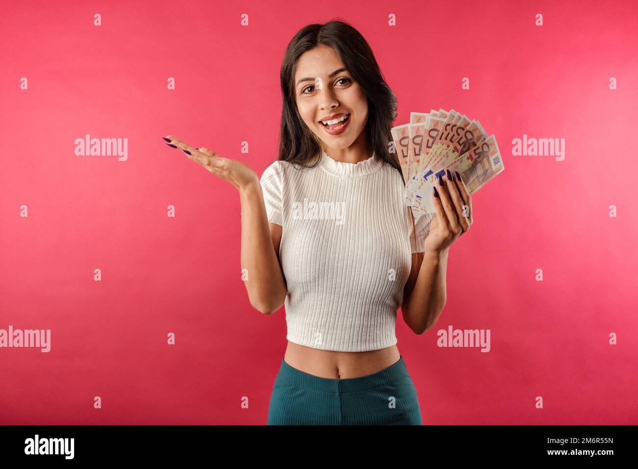 Happy young woman wearing white ribbed crop isolated over red ...