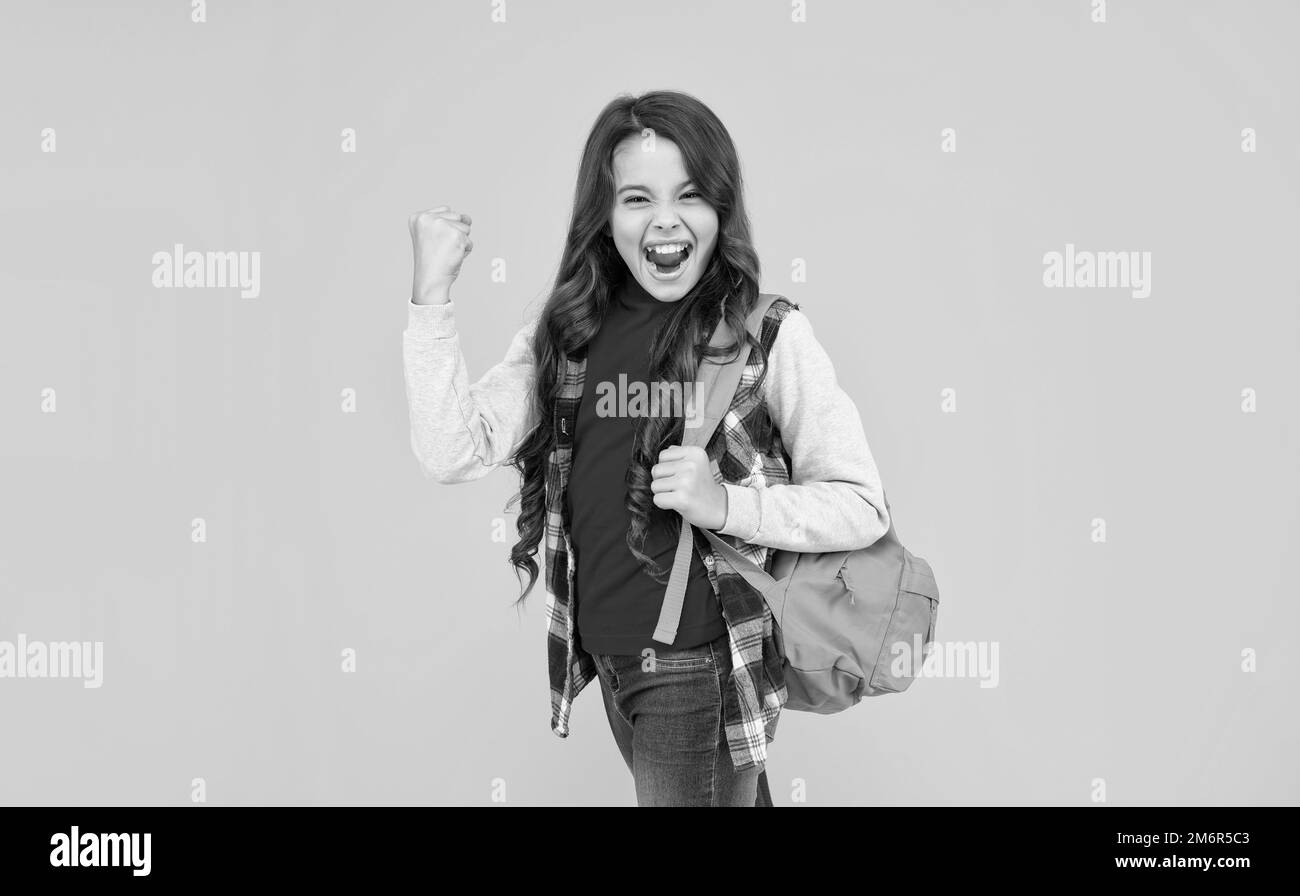 successful kid has long curly hair carry school backpack on yellow ...