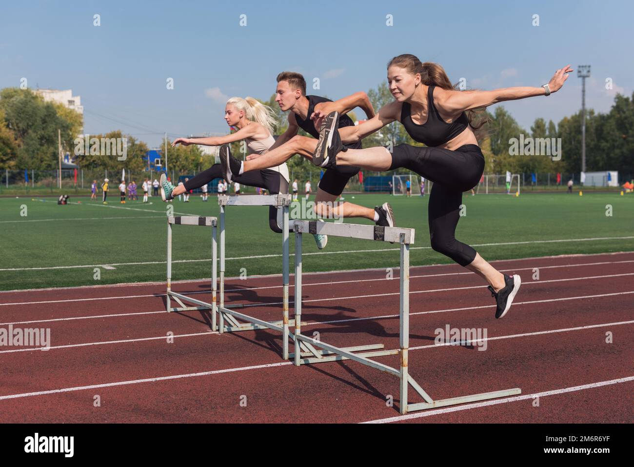 Two athlete woman and man runnner running hurdles Stock Photo - Alamy