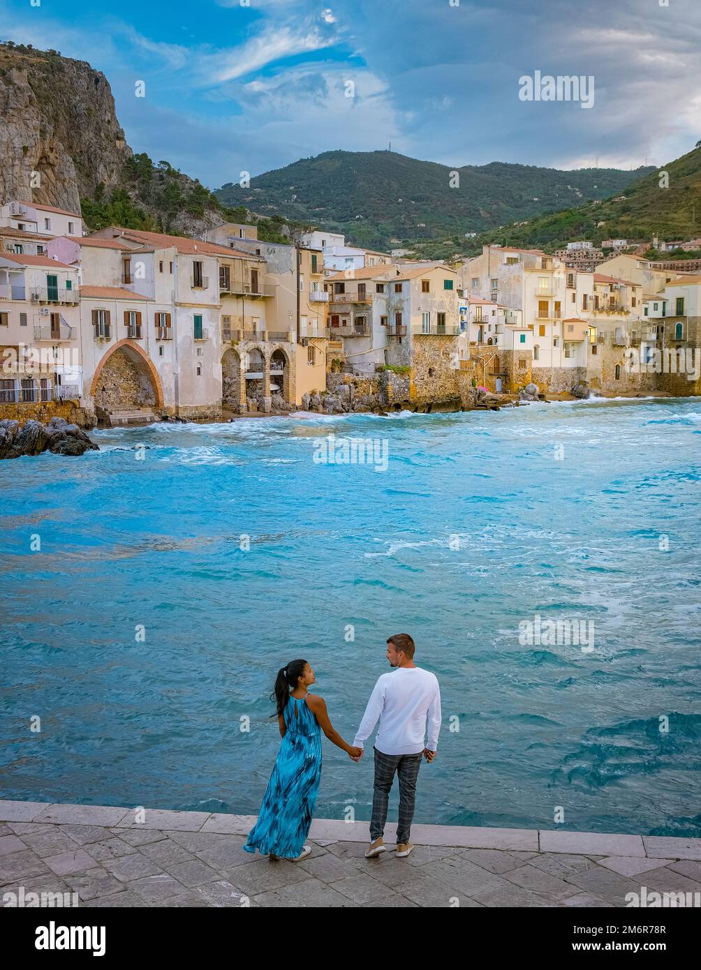 Cefalu Sicily, couple watching sunset at the beach of Cefalu Sicilia ...