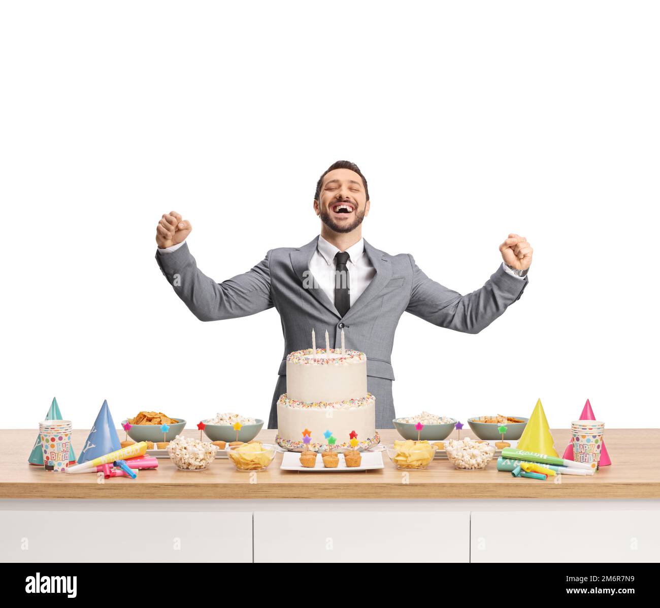 Excited young man in a suit standing behind a counter with a cake Stock ...