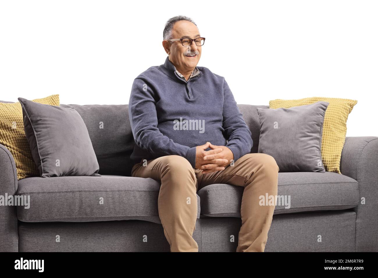 Smiling mature man sitting on a sofa isolated on white background Stock ...