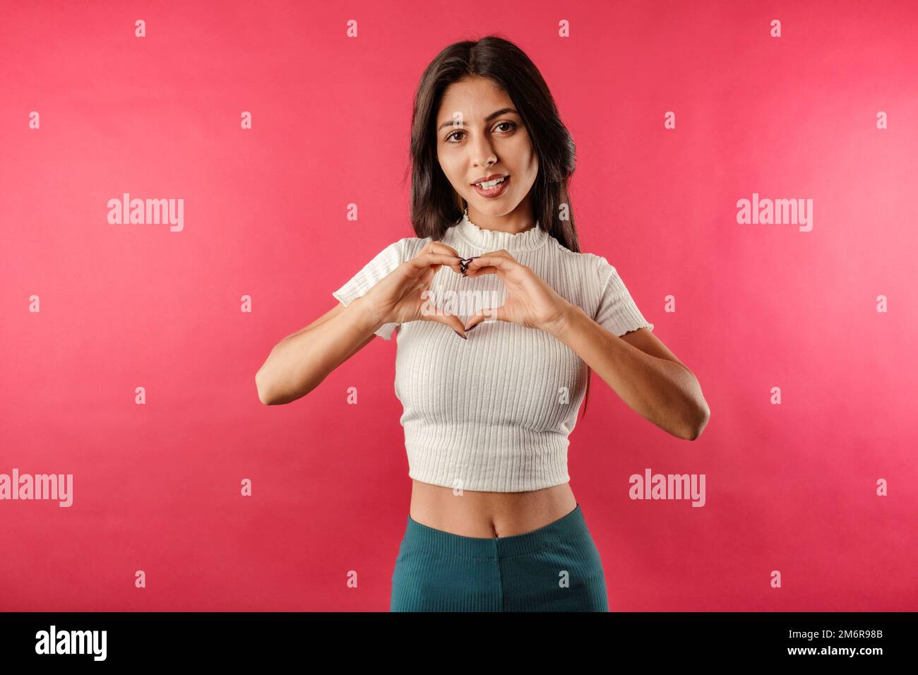 Cute Brunette Woman Wearing White Ribbed Crop Isolated Over Red
