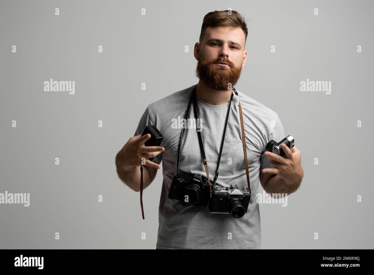 Portrait of bearded photographer with a bunch of different vintage old ...