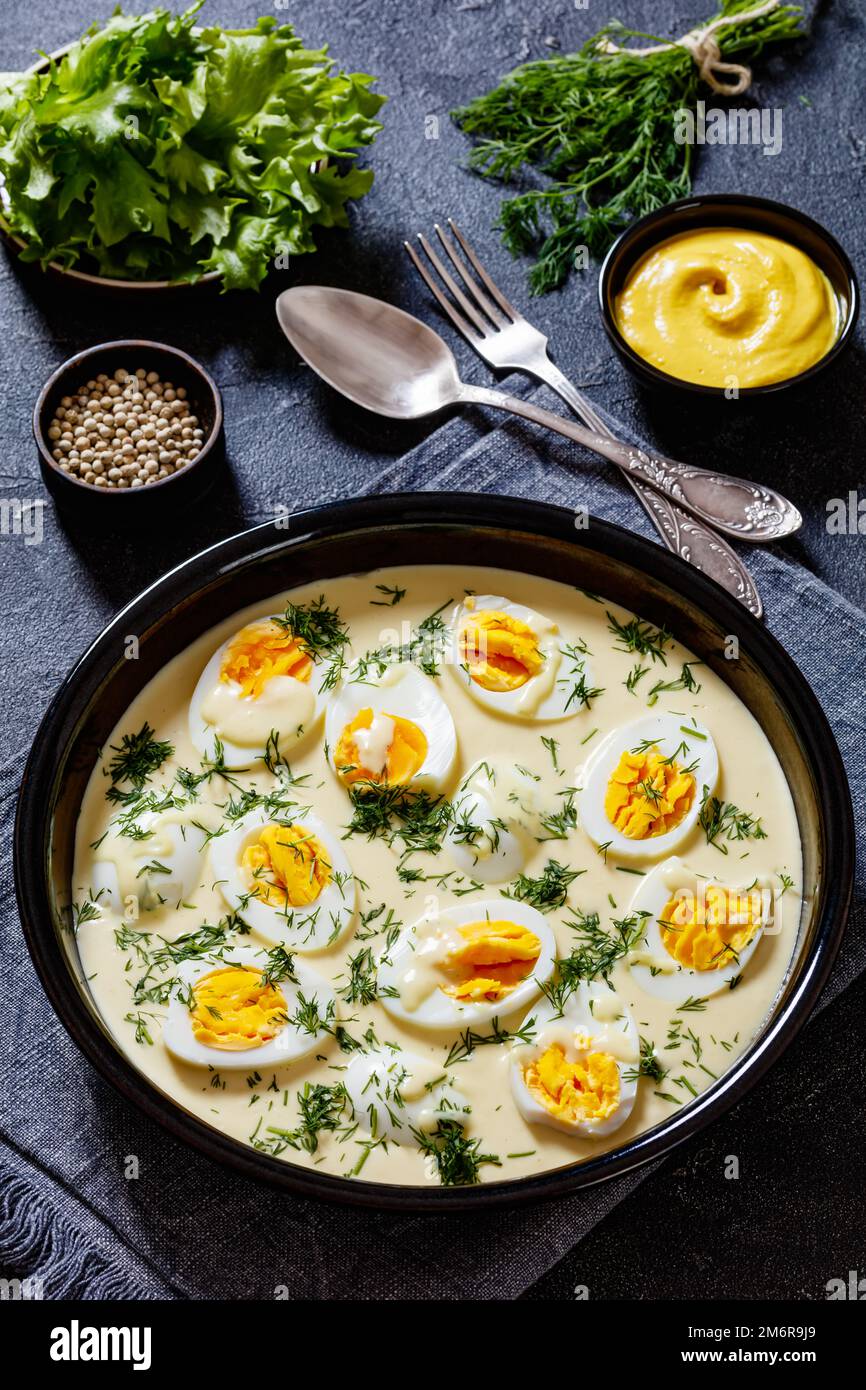 Senfeier, hard boiled eggs in rich creamy mustard sauce in black bowl ...