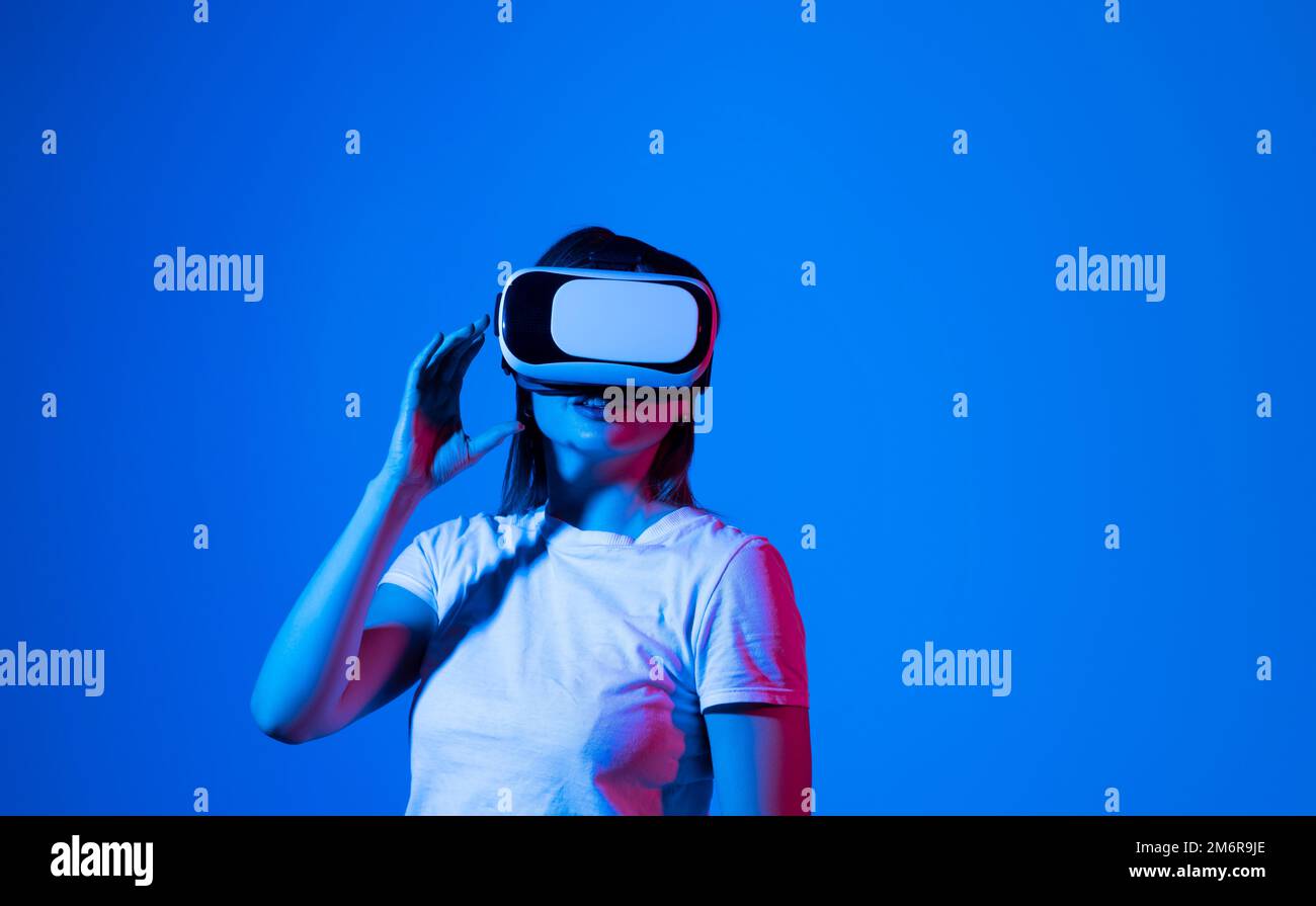 Brunette woman in white shirt wearing VR glassess, VR headset equipment ...