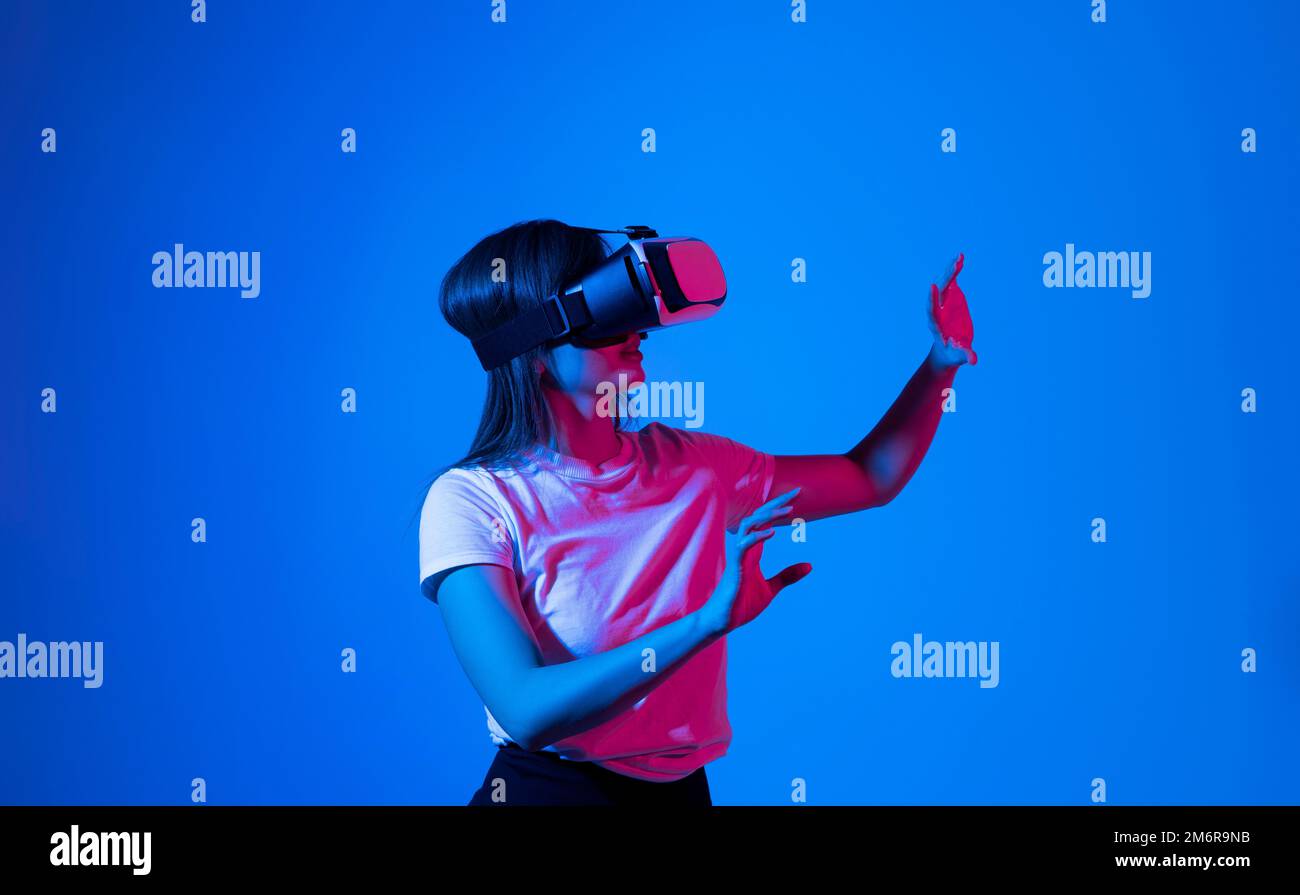 Woman wearing a VR headset and interacting with virtual reality. Simulation, future technology ...