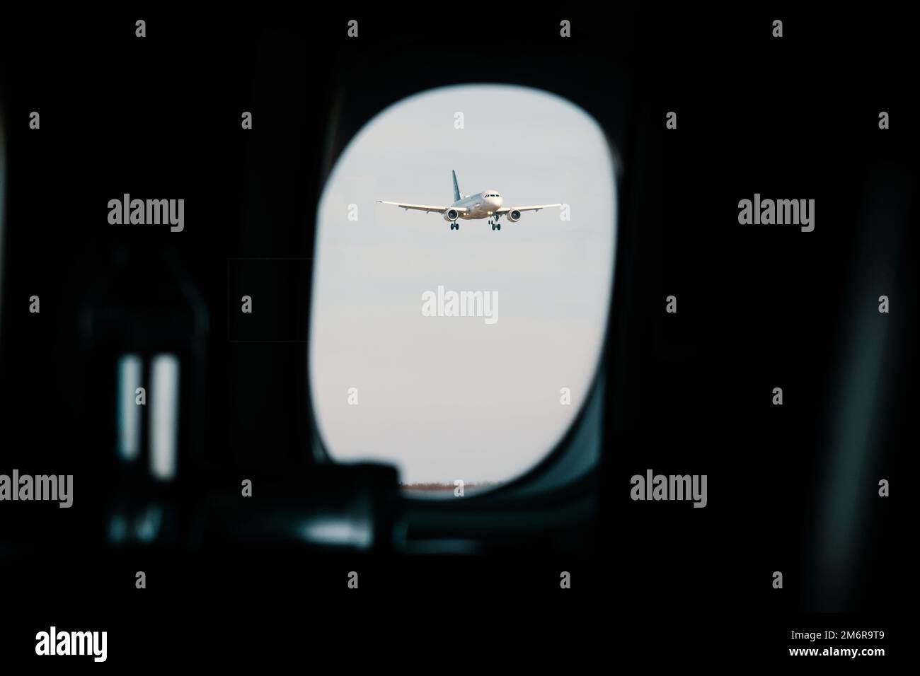 A beautiful shot of an airplane flying near an airport visible through ...