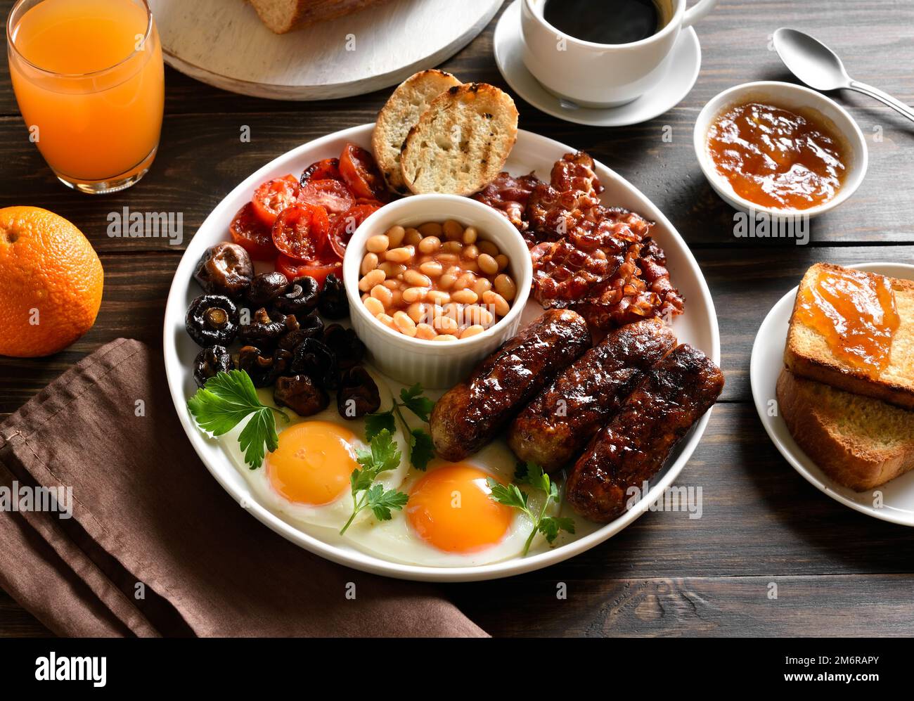 Full English breakfast with fried egg, bacon, sausage, beans and ...
