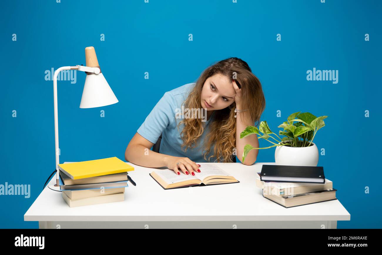 Tired student having a lot of work in a library. Too much work tired ...