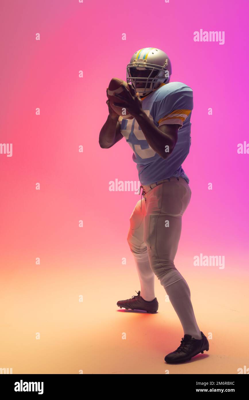 African american male american football player holding ball with neon ...