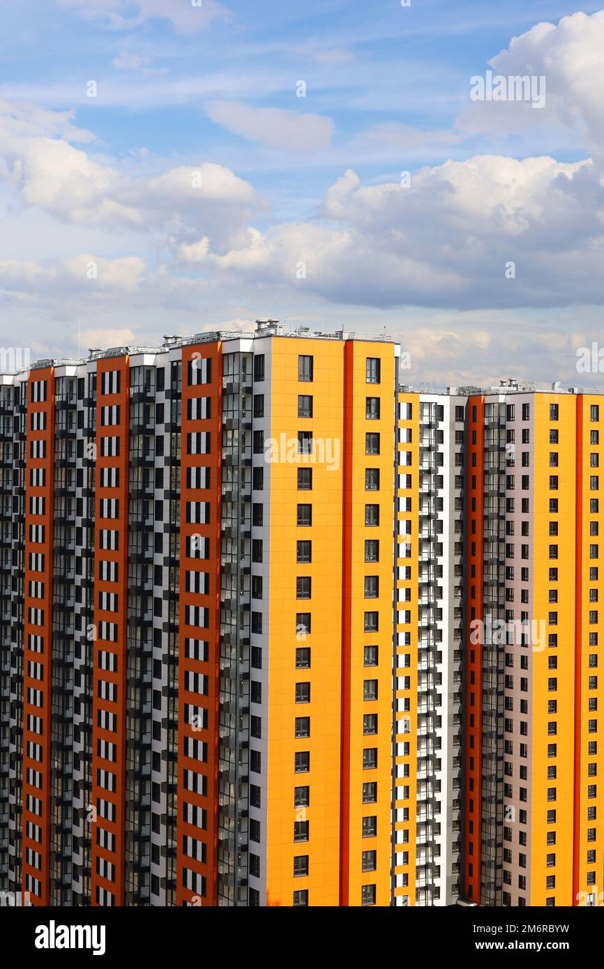 New residential buildings with orange and yellow cladding on background ...