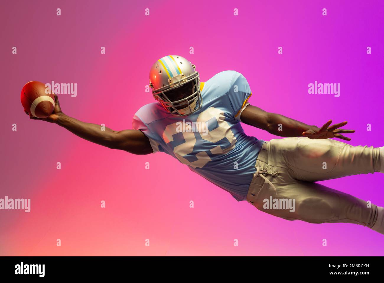 African american male american football player holding ball with neon ...