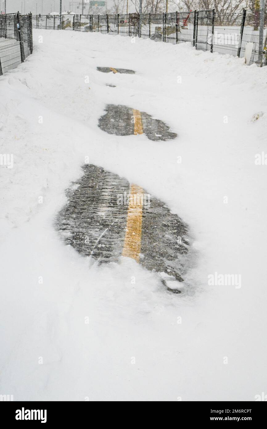 Road under the snow. Close-up of snow on the road. Impossibility of ...