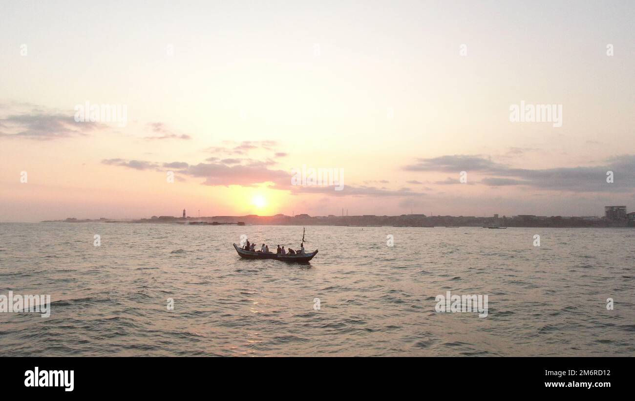 A beautiful shot of a boat floating on water at sunset in Accra, Ghana ...