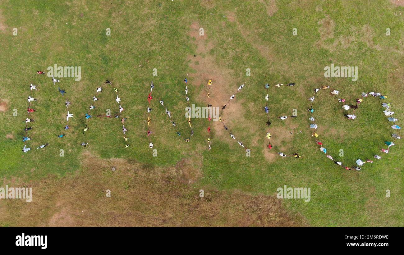 An aerial top view of children standing to spell out danke in german on ...