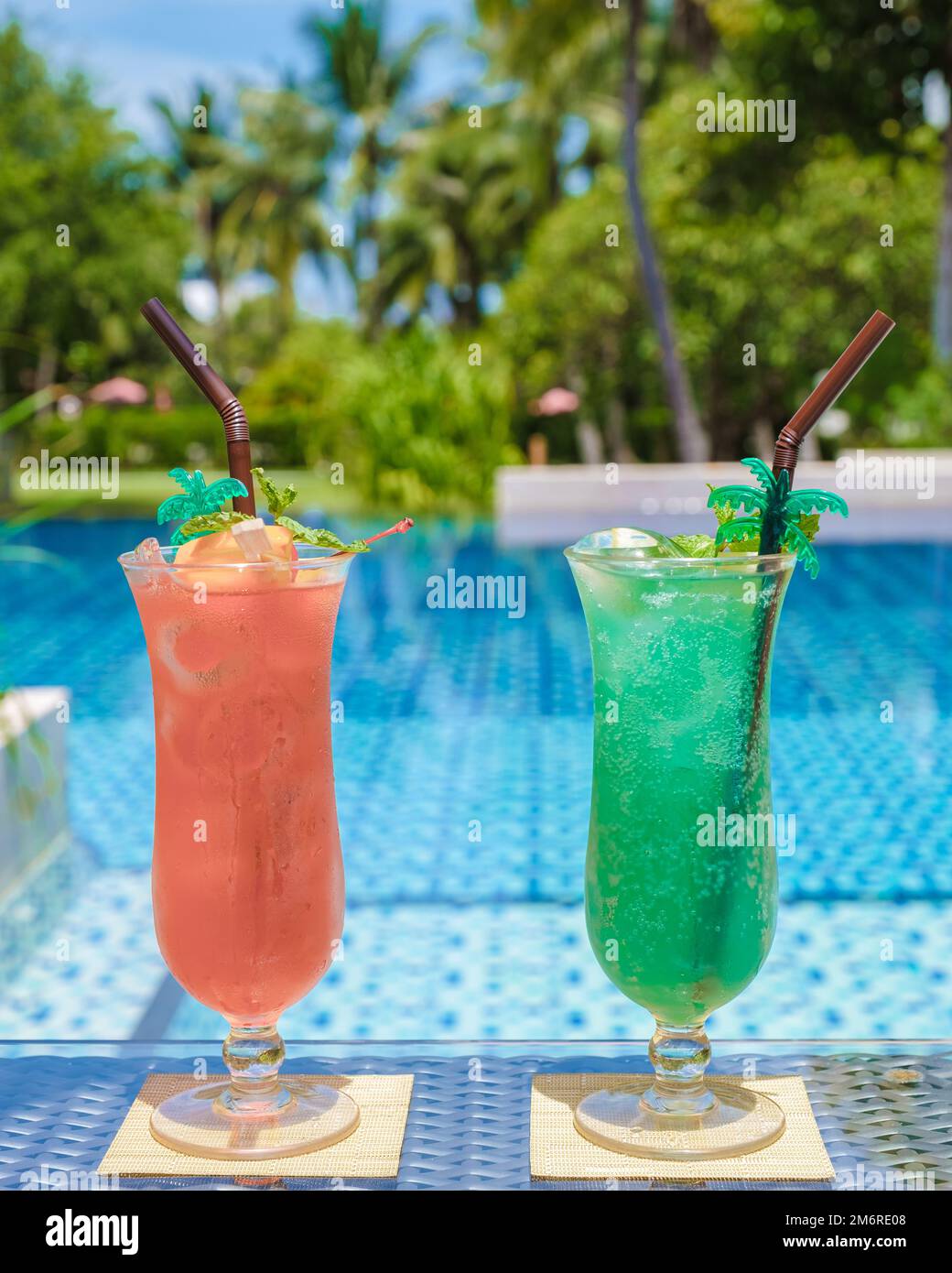 Colorful mocktail at a pool bar, orange and green cocktail by the pool ...