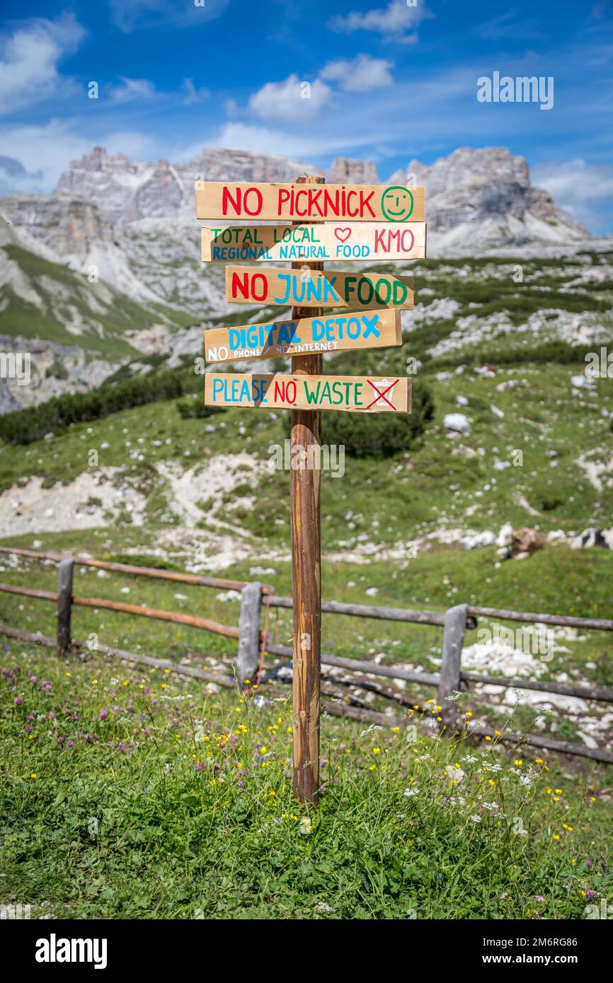 Colourful signs in front of Alpine hut Langalm, rock massif at the back ...