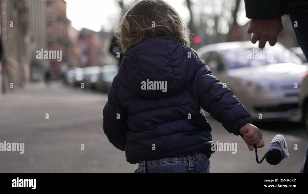 Baby toddler running in sidewalk during winter outside. Infant ...