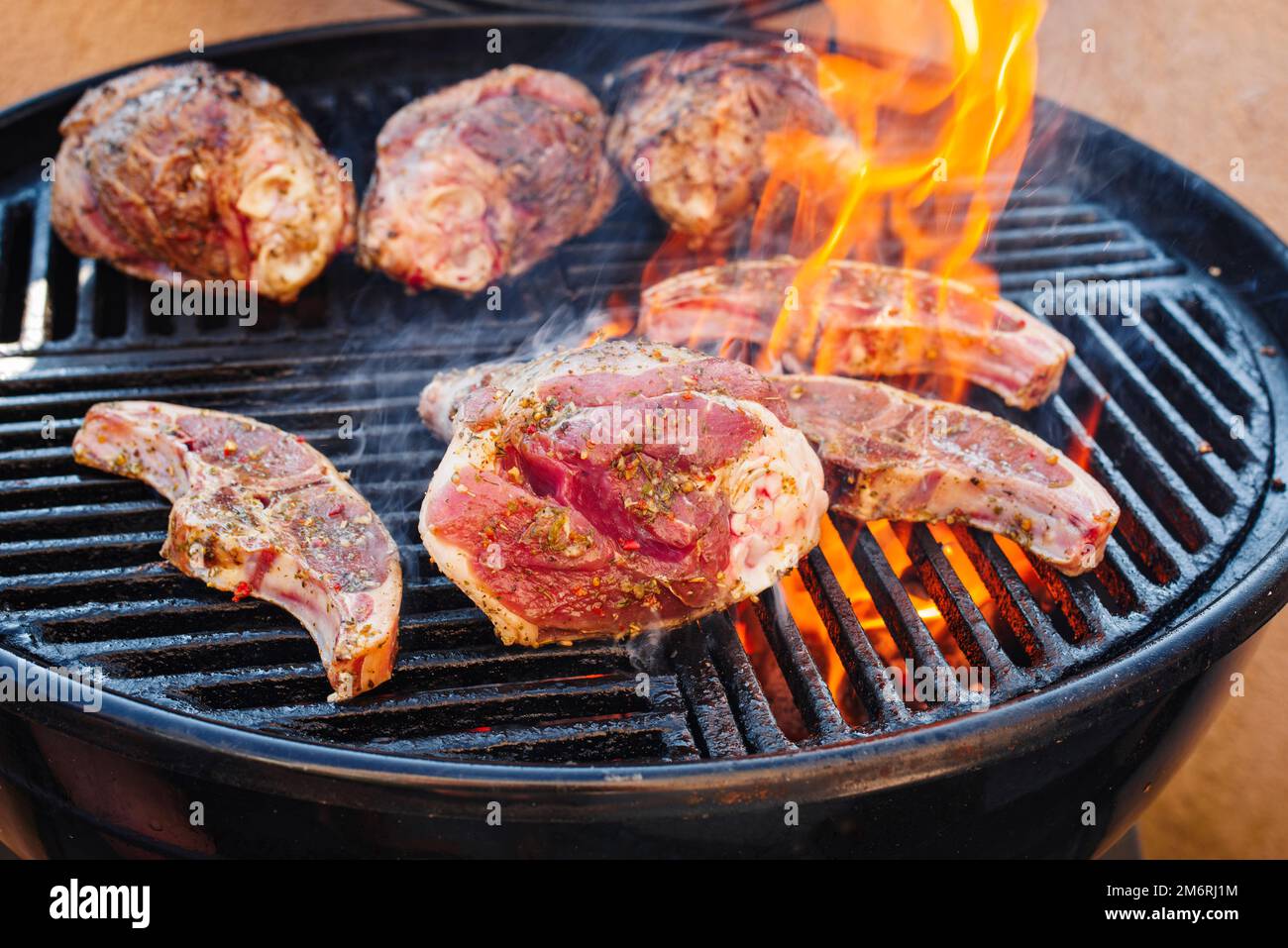 Raw traditional barbecue lamb shanks and saddle grilled as close-up on ...