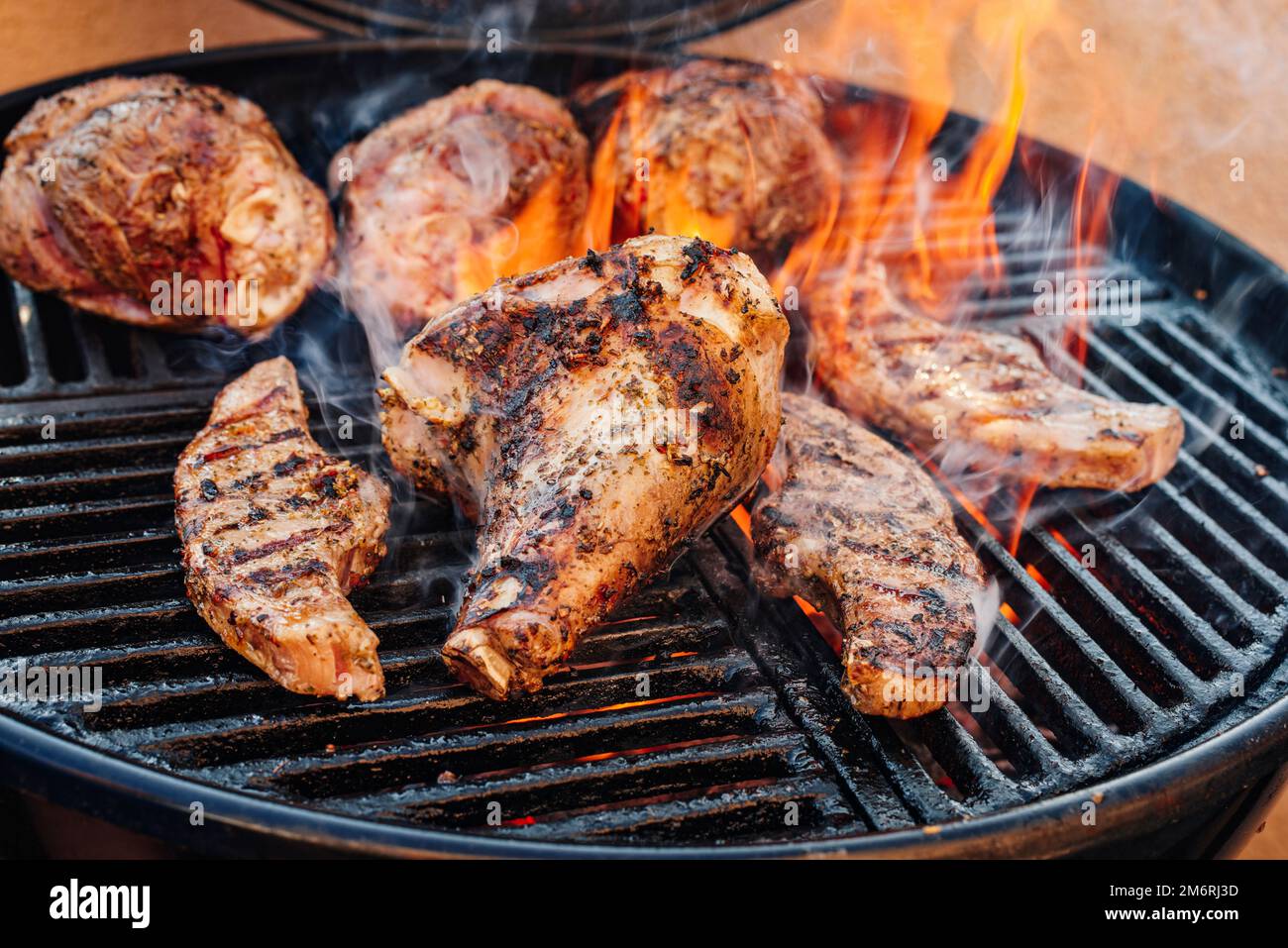Traditional barbecue lamb shanks and saddle grilled as close-up on a ...