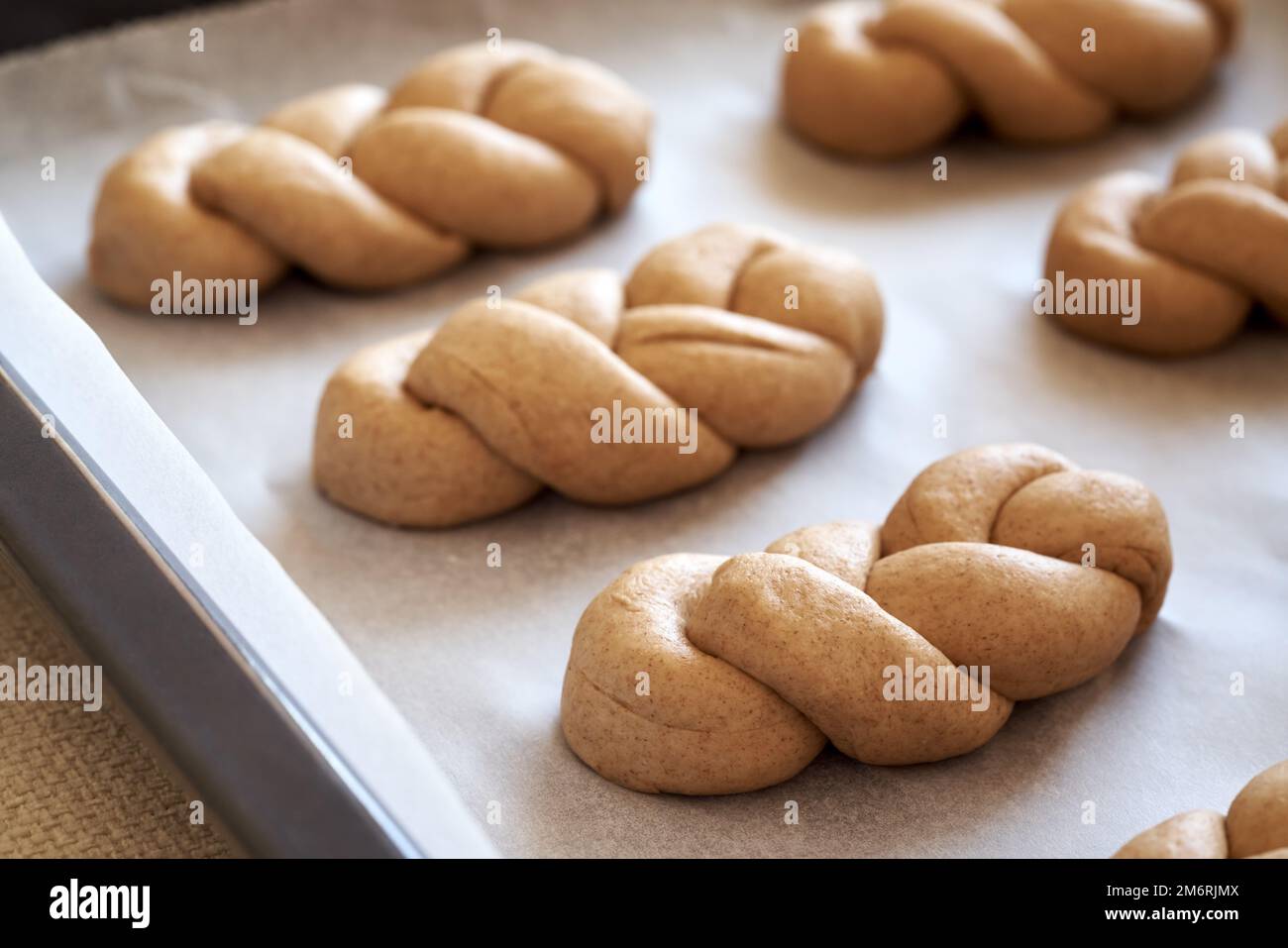Raw braided bread rolls made of whole grain spelt flour, before baking ...