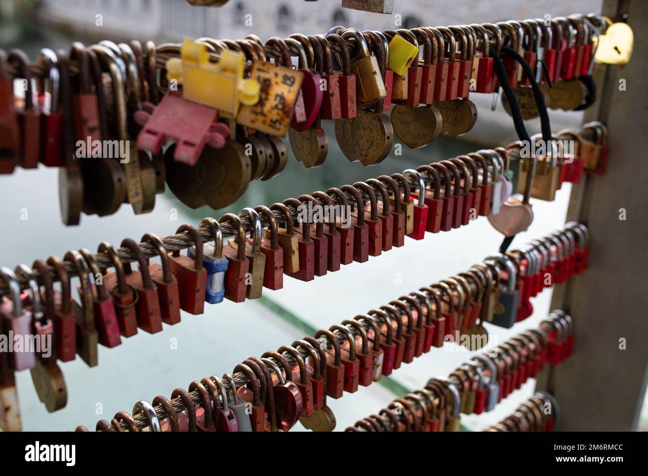 closed padlocks hanging from the railing of the mesarski bridge ...