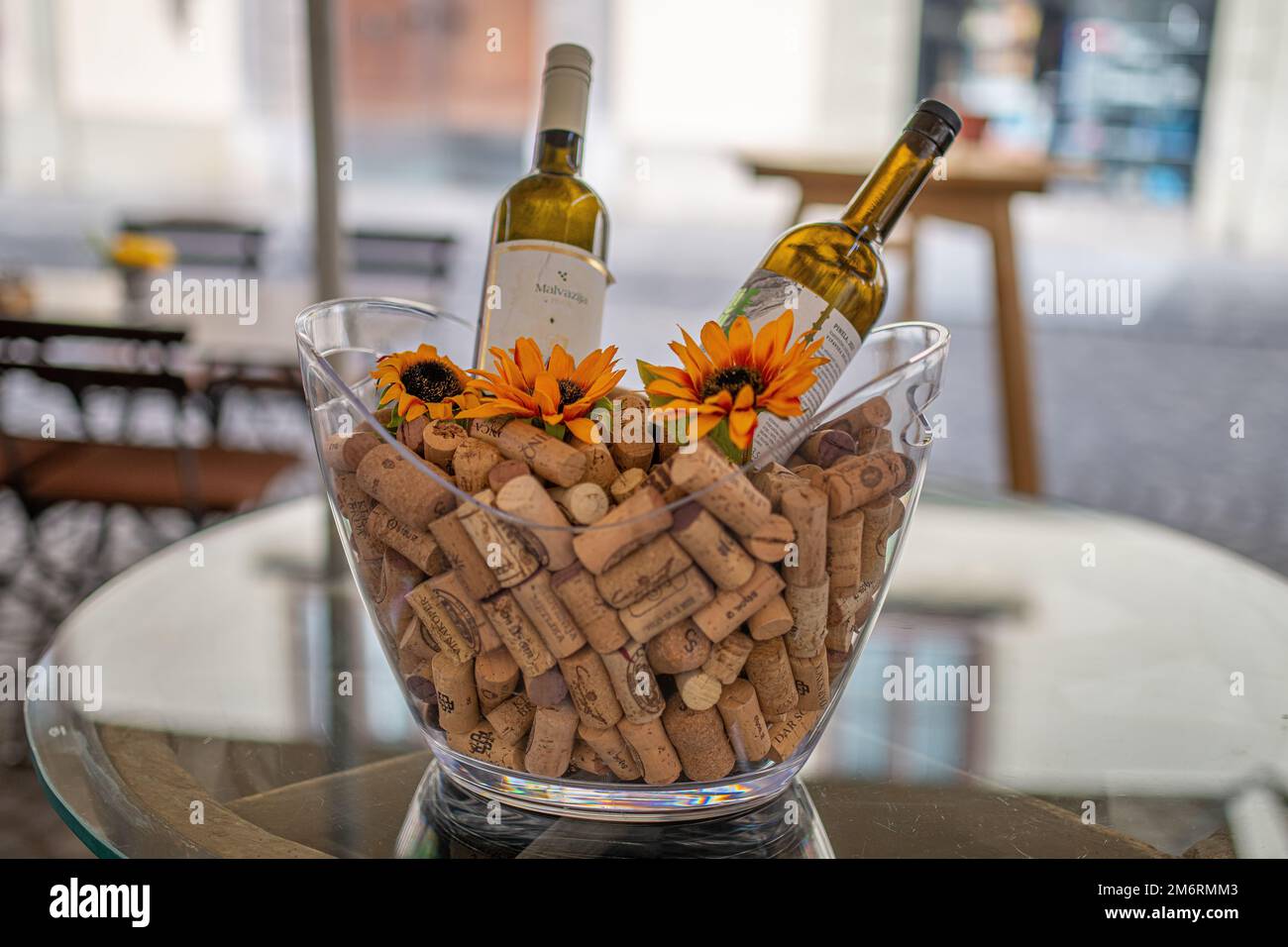 wine bottles inside a glass container filled with corks Stock Photo - Alamy