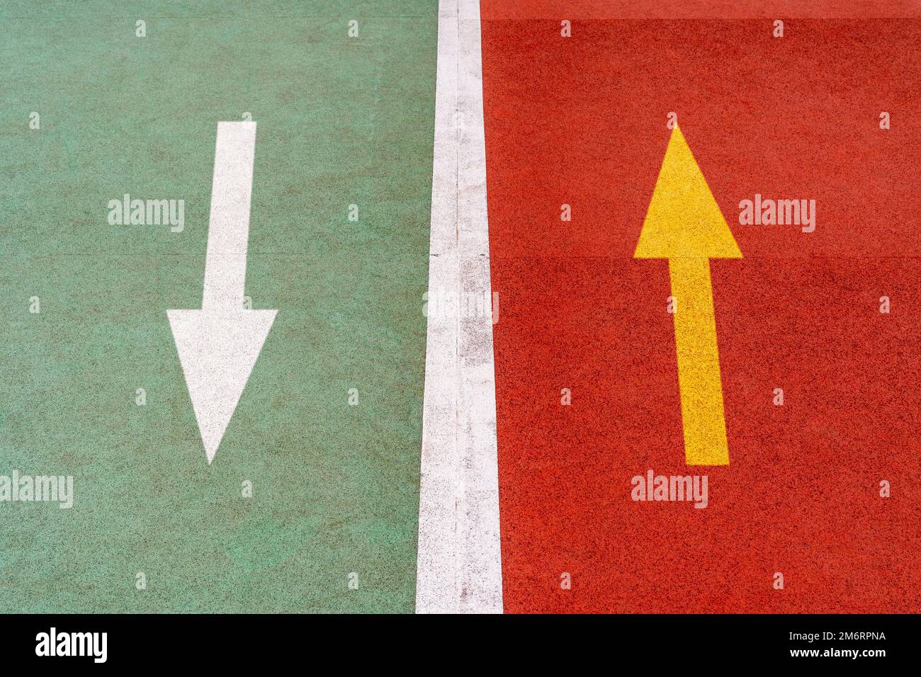 A two way arrows pointing in opposite directions symbol on a road surface Stock Photo - Alamy