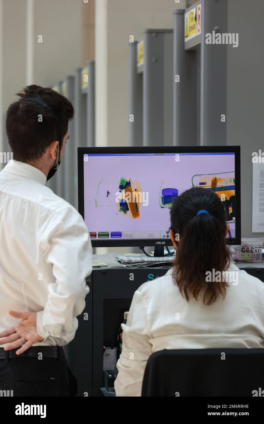 Security personnel checking bags and backpacks x-rayed at the access ...