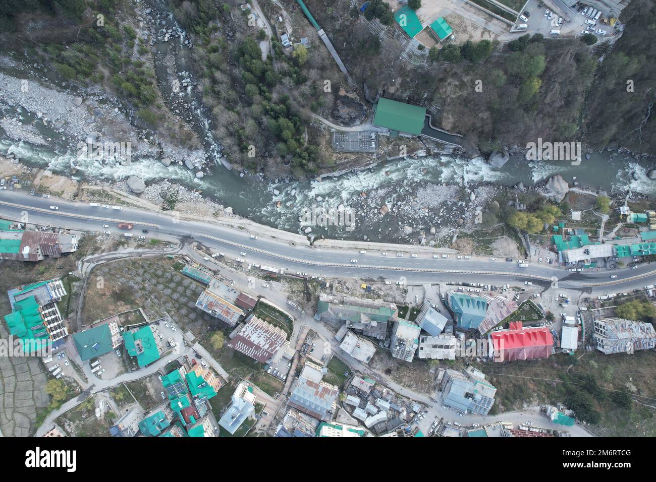 An aerial view of green forest trees near houses in the countryside of ...