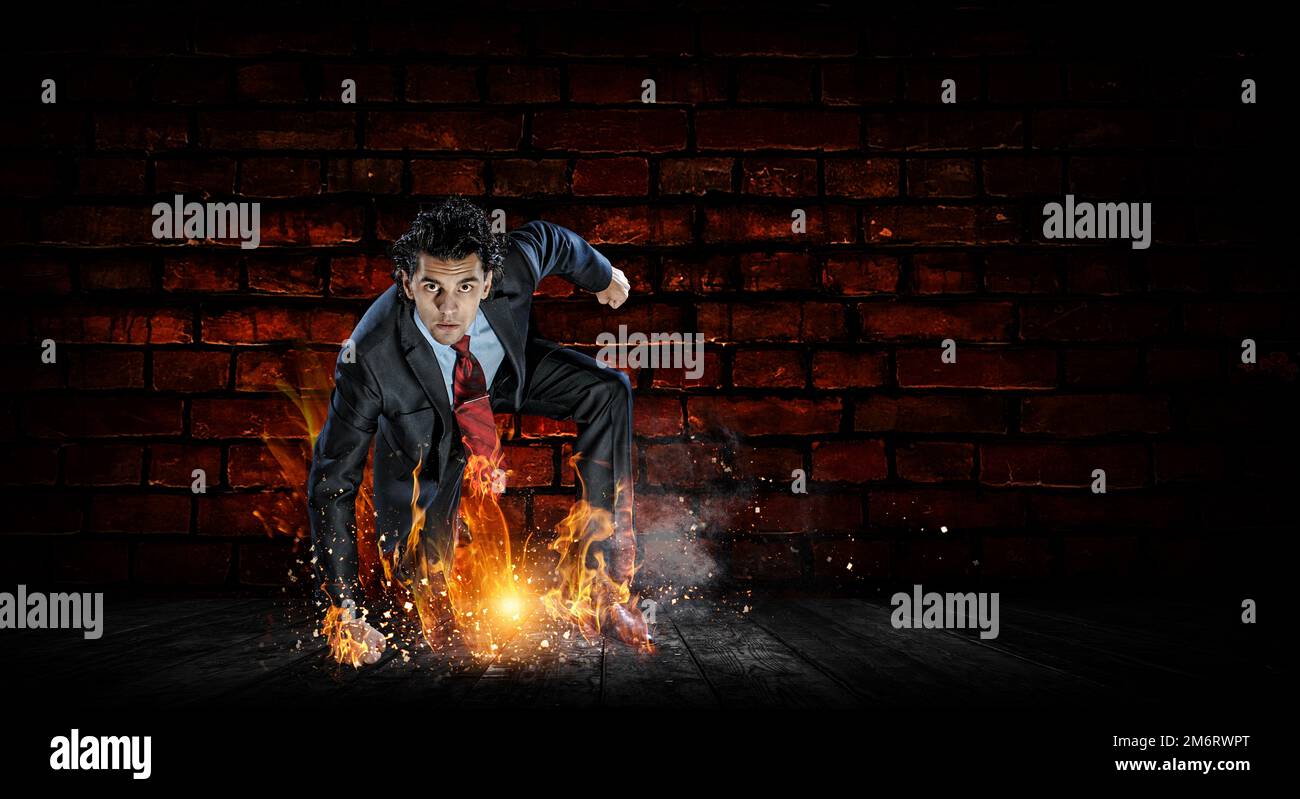 Determined businessman leaving fire trails on asphalt Stock Photo - Alamy