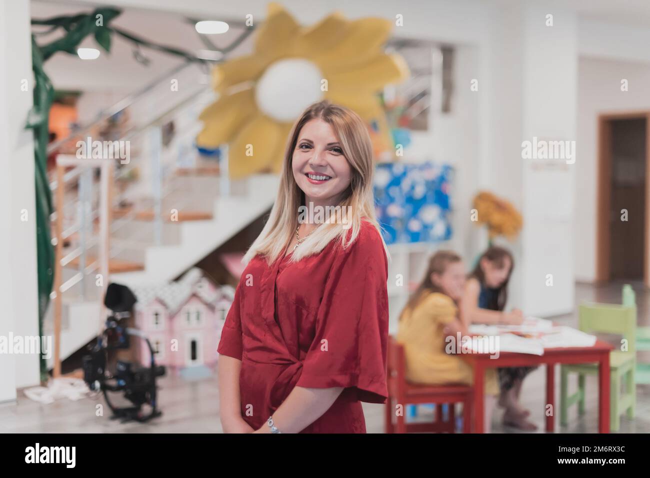 Portrait of a teacher in a preschool institution, in the background of ...