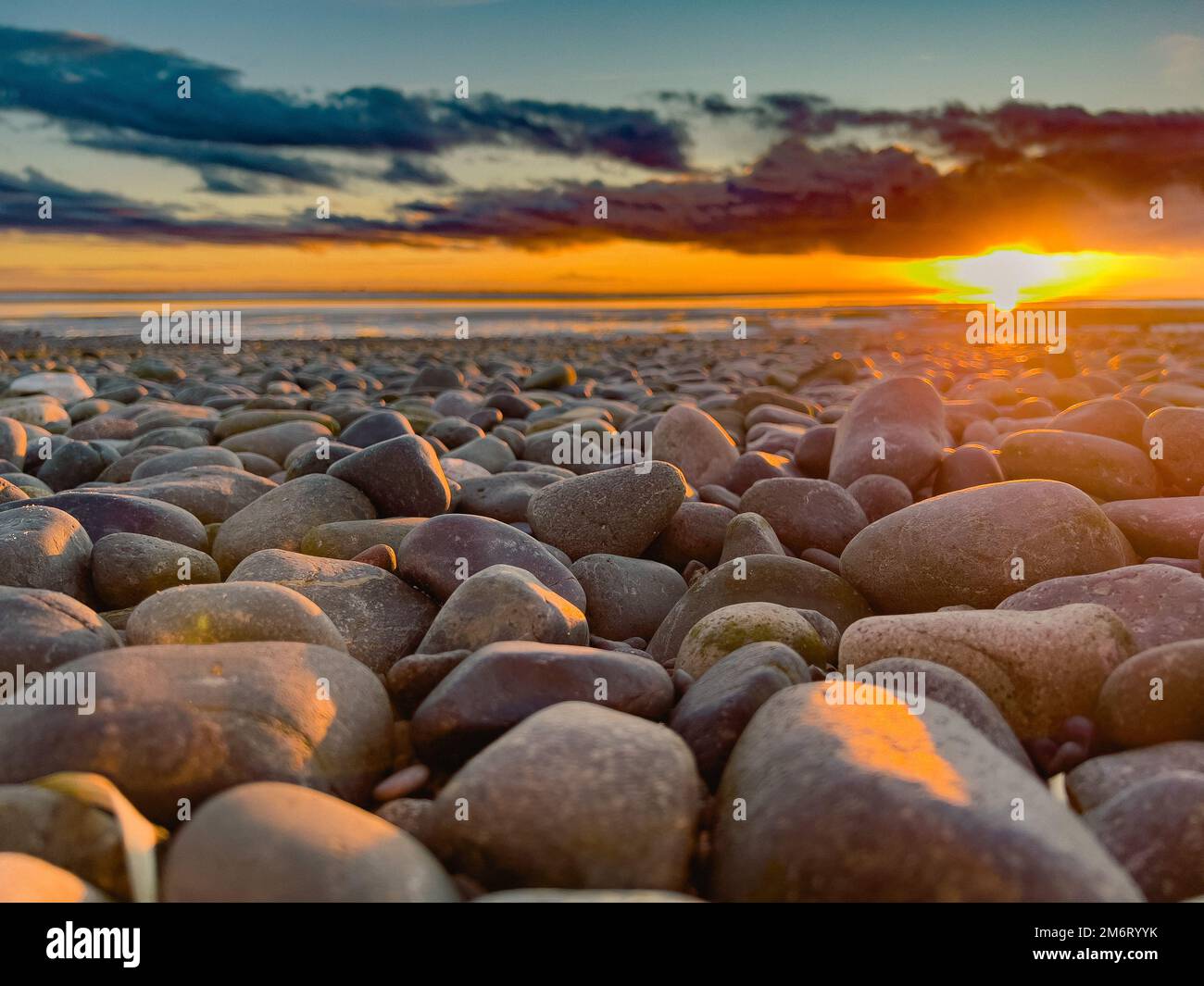 Sunset on a Pebble Beach Stock Photo - Alamy