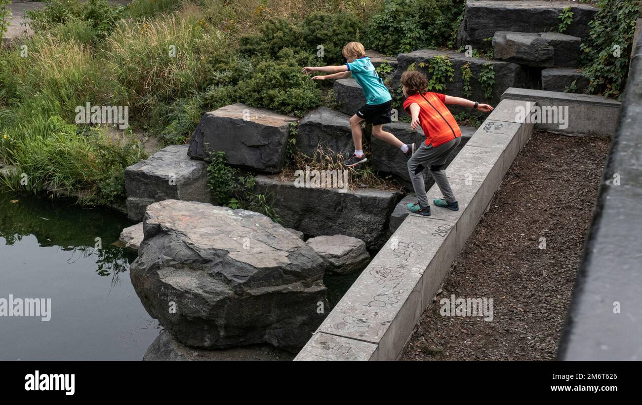 Boys jumping across boulders hi-res stock photography and images - Alamy