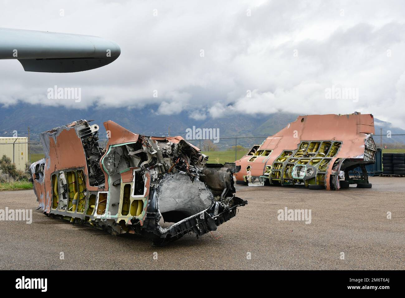 A salvaged F-35A fuselage sits in two sections after being cut in half ...