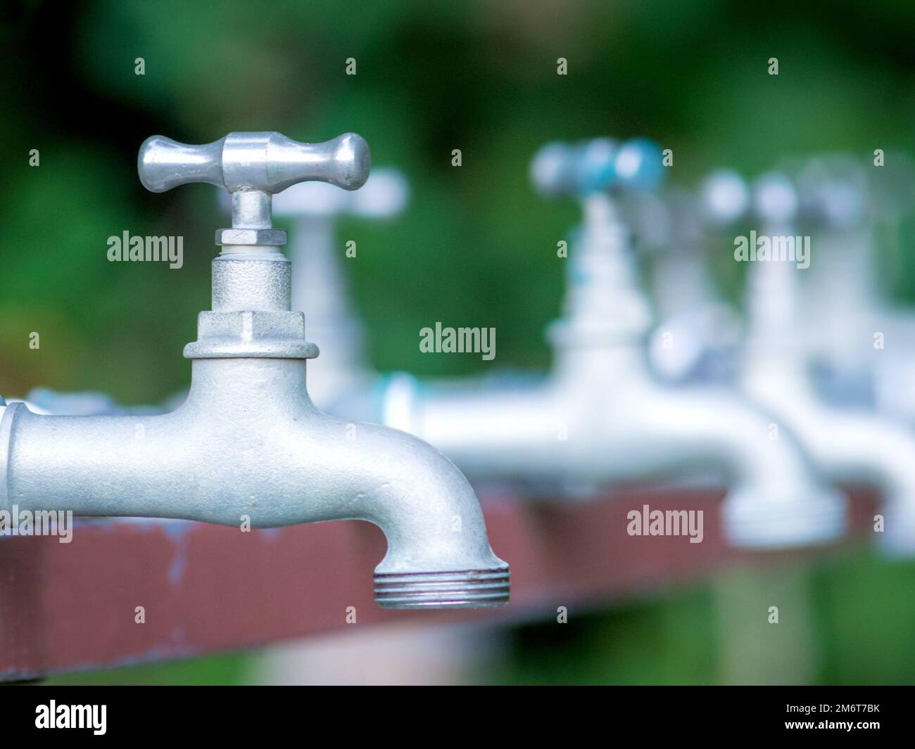 Brass water tap in nature background Stock Photo - Alamy