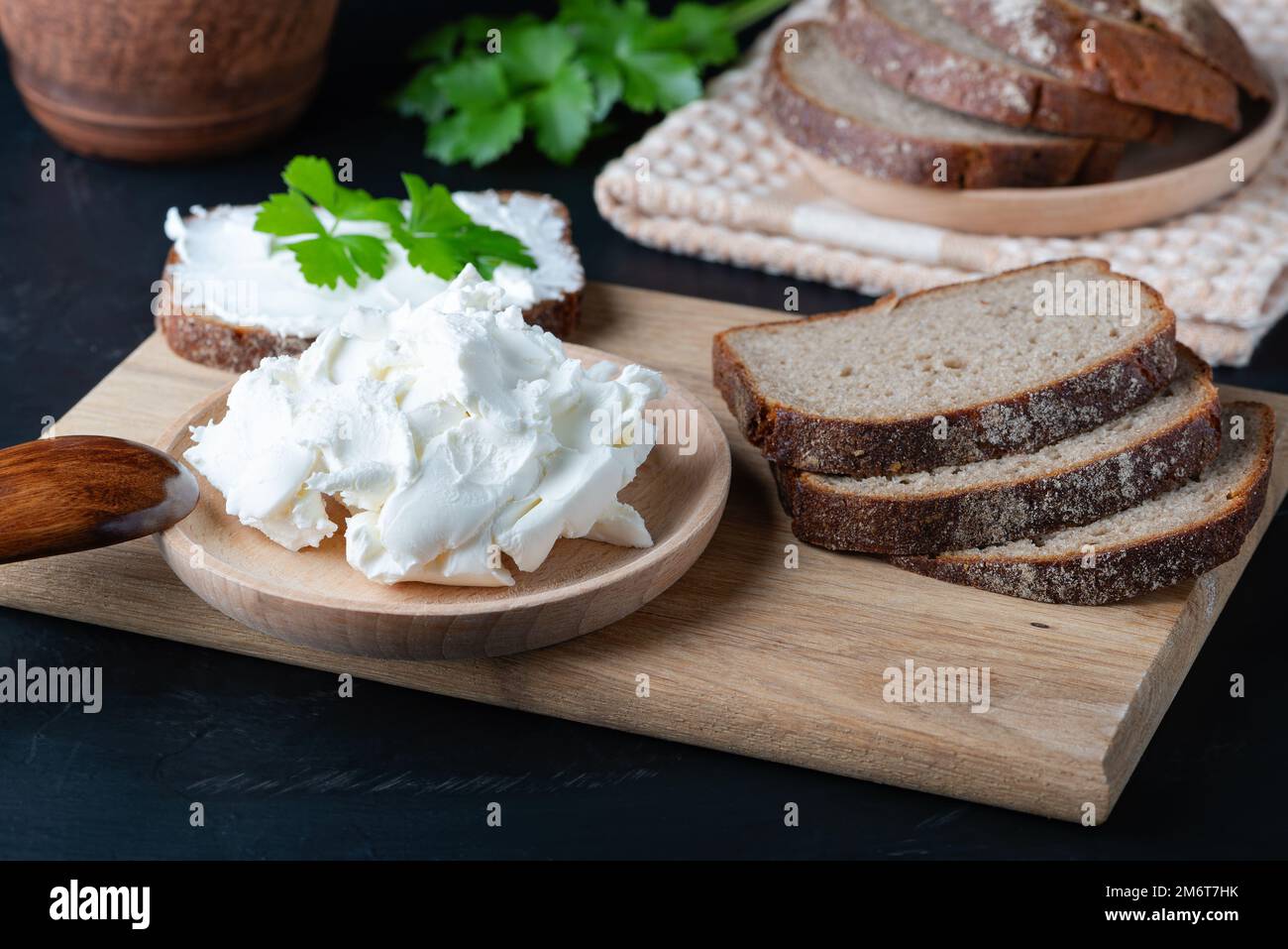 Home made bread on a wooden cutting board with curd cheese and ricotta ...