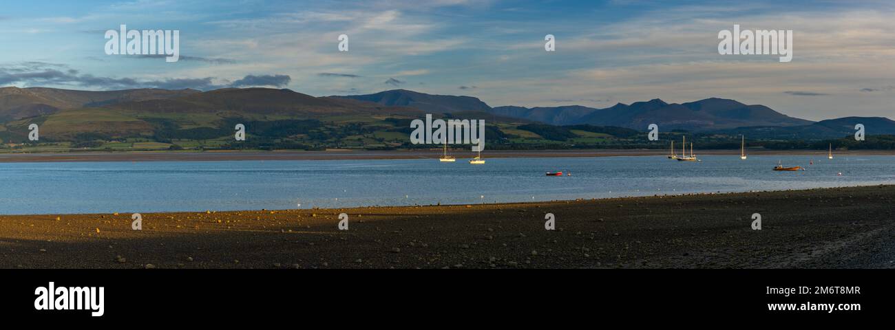 A panorama landscape of the Menai Strait with many boats at anchor and ...