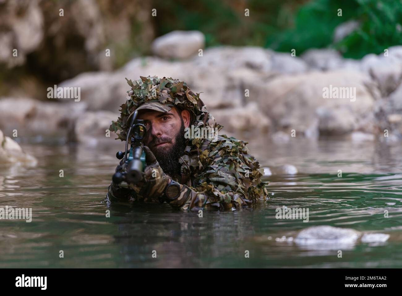 A military man or airsoft player in a camouflage suit sneaking the ...
