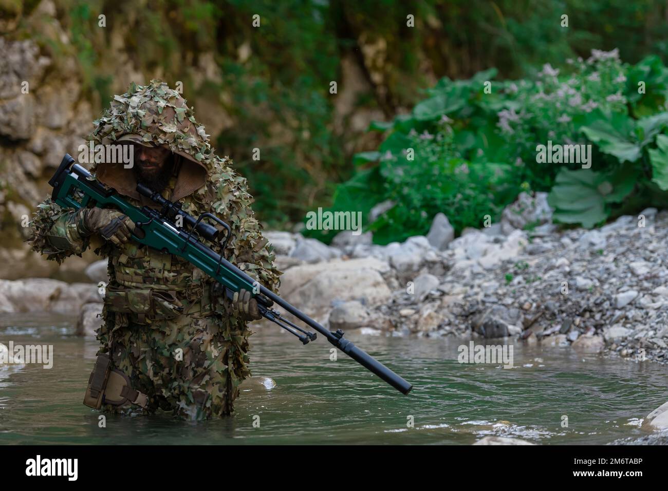 A military man or airsoft player in a camouflage suit sneaking the ...
