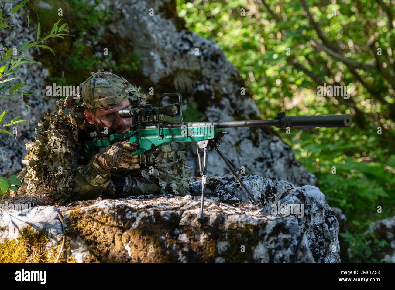 A military man or airsoft player in a camouflage suit sneaking the ...