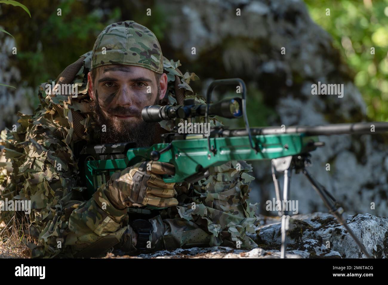 A military man or airsoft player in a camouflage suit sneaking the ...