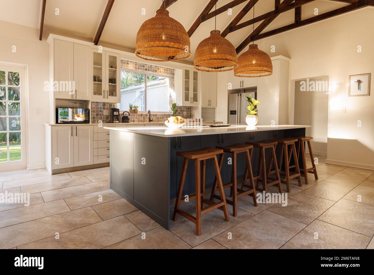 General view of modern kitchen with countertop, chairs and kitchen ...