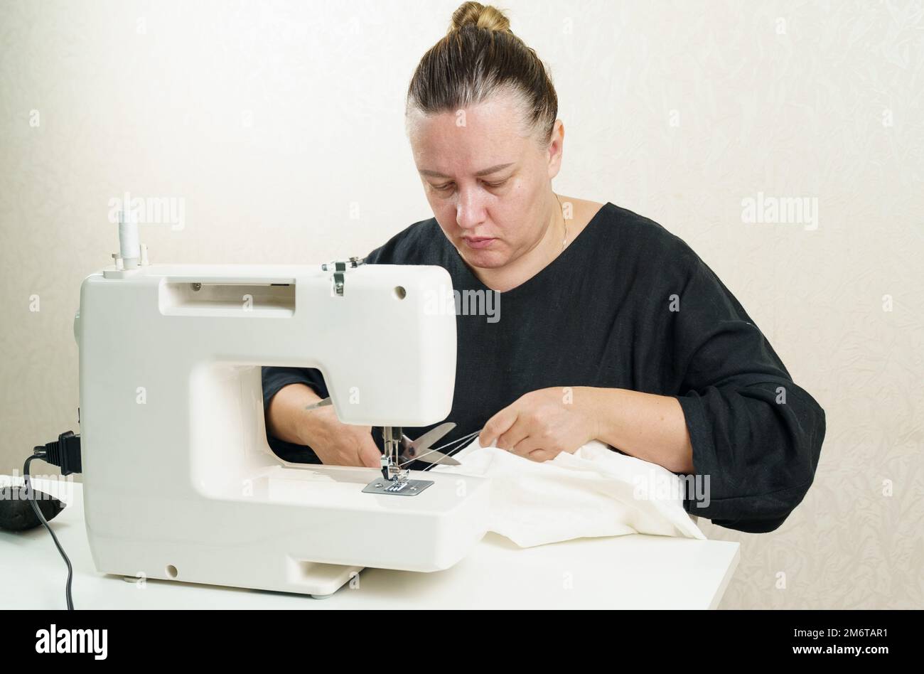 Work at home. Small business. Portrait of a female seamstress who sews ...