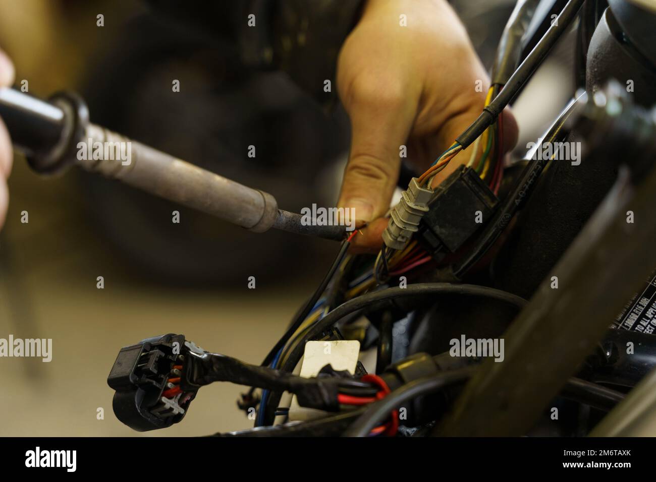 An electrician is soldering electrical wires to electrical equipment in ...