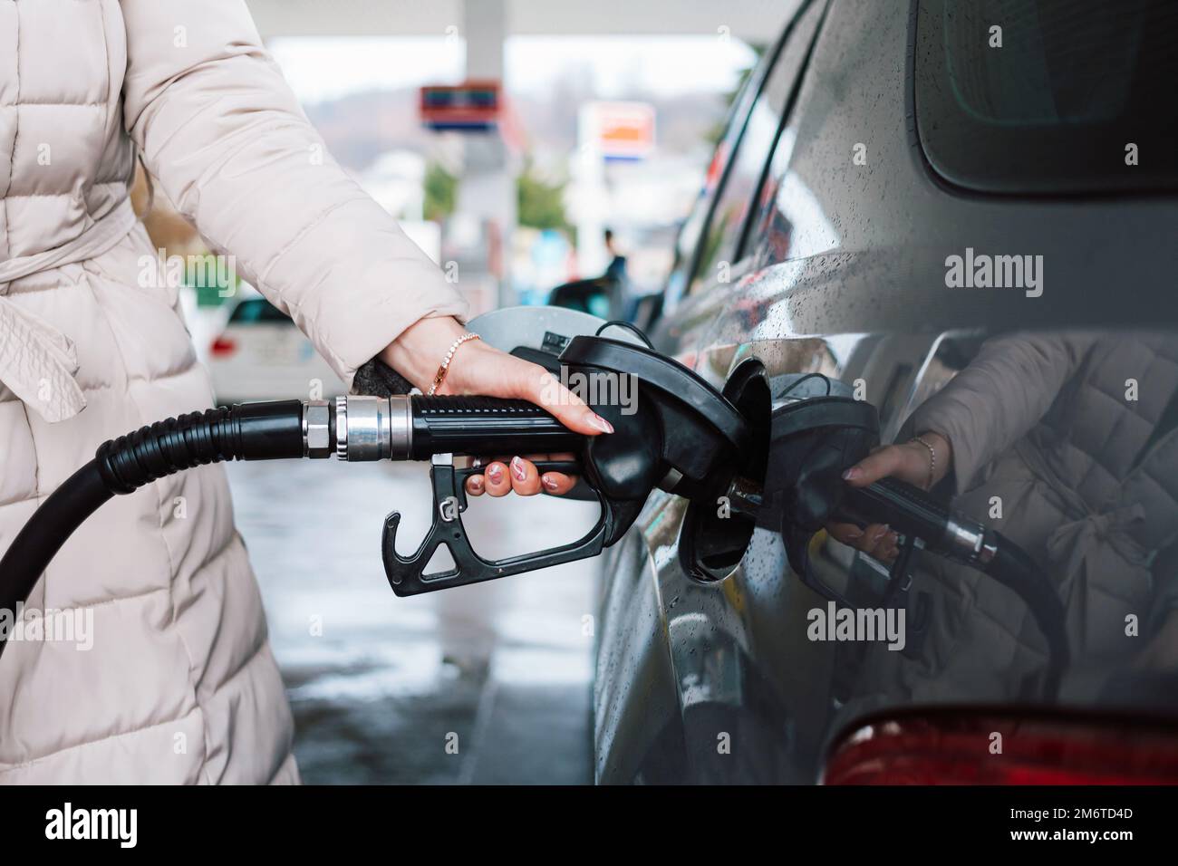 Woman pumping gasoline fuel in car at gas station. Petrol or gasoline ...