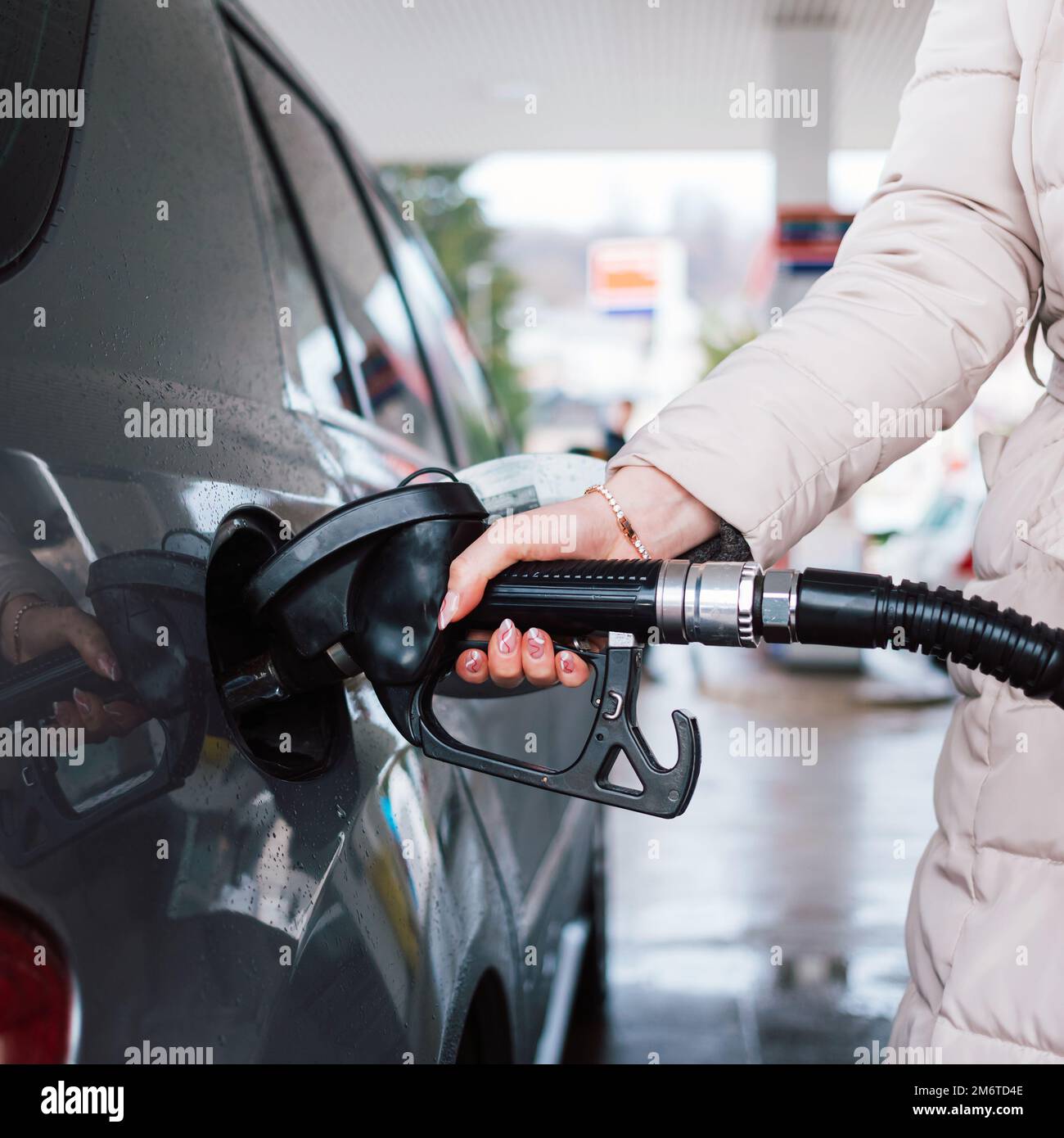 Woman pumping gasoline fuel in car at gas station. Petrol or gasoline ...