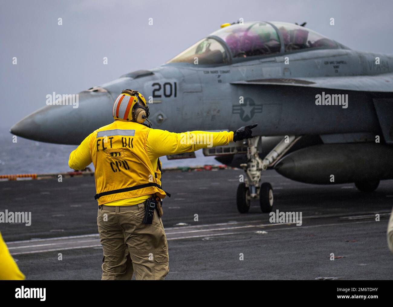 230105-N-MH015-1062 PHILIPPINE SEA (Jan. 5, 2023) A U.S. Navy Sailor directs an F/A-18E Super ...