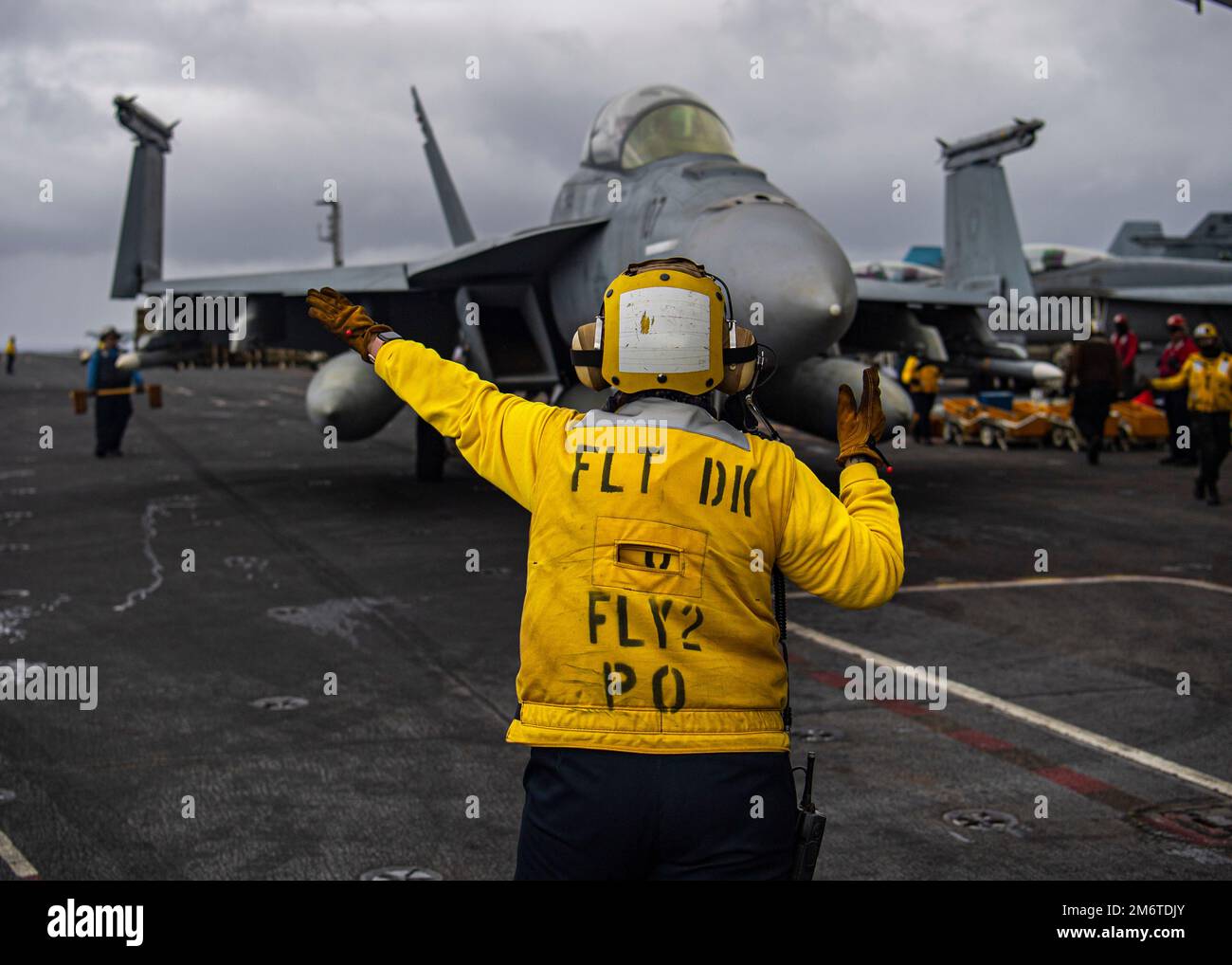 230105-N-MH015-1035 PHILIPPINE SEA (Jan. 5, 2023) A U.S. Navy Sailor directs an F/A-18E Super ...
